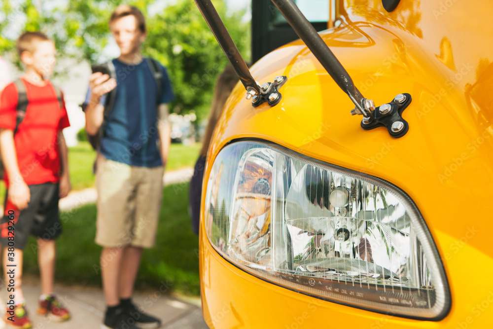 School Bus: Focus On Headlight With Boys In Background Stock Photo ...