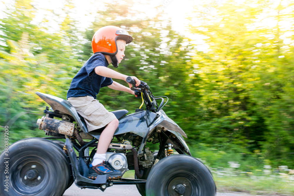 Boy Riding Fast Gas Powered Jr Kids ATV Quad On Trail With Sunflare on ...
