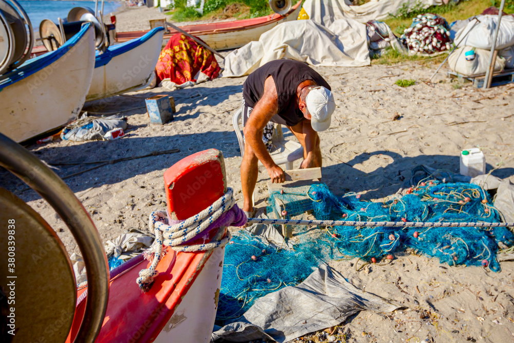 Fisherman cleans the fishing net, breaks the shells Stock Photo | Adobe ...
