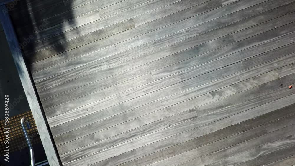 Birds eye view drone footage of people on a decking, no faces, then the ...