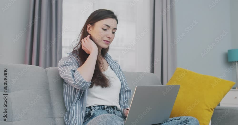 Concentrated beautiful Caucasian dark-haired girl working on laptop ...