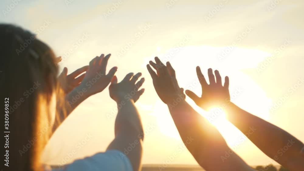 People's hands reach out to the sun and god at sunset. Happy family ...