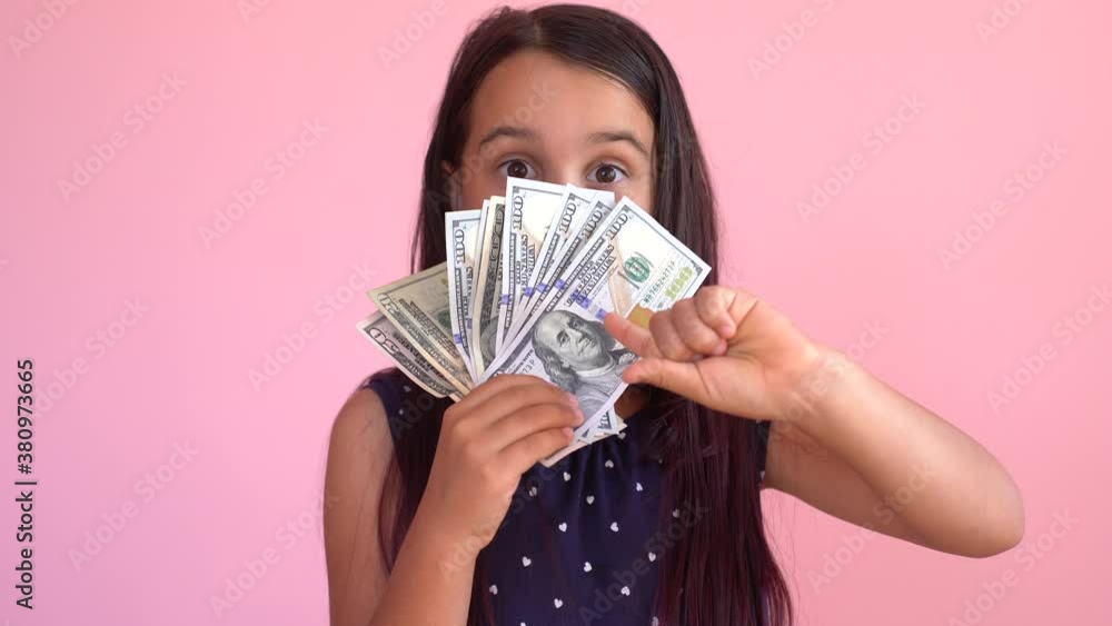 Little caucasian child girl receives money income in banknotes dollar ...