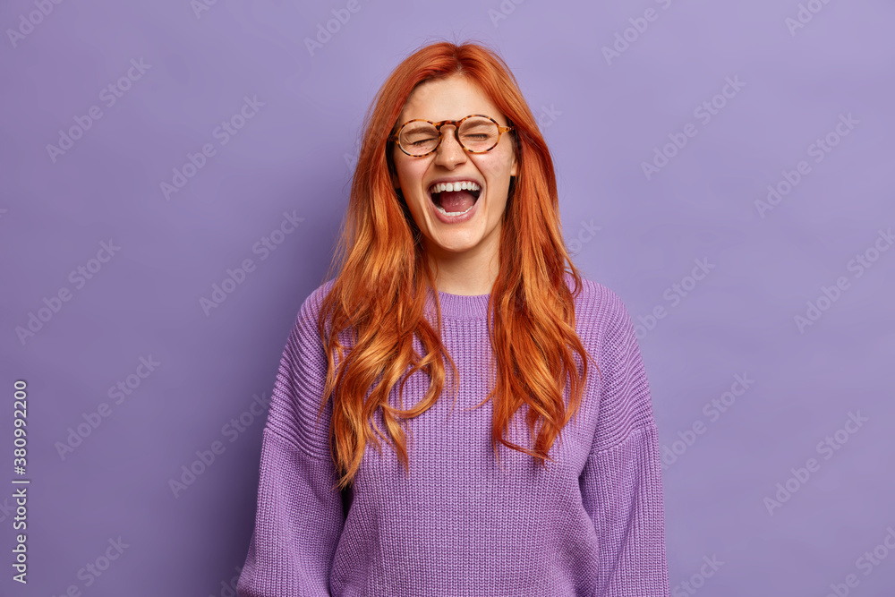 Emotional ginger woman cannot stop laughing keeps mouth widely opened ...