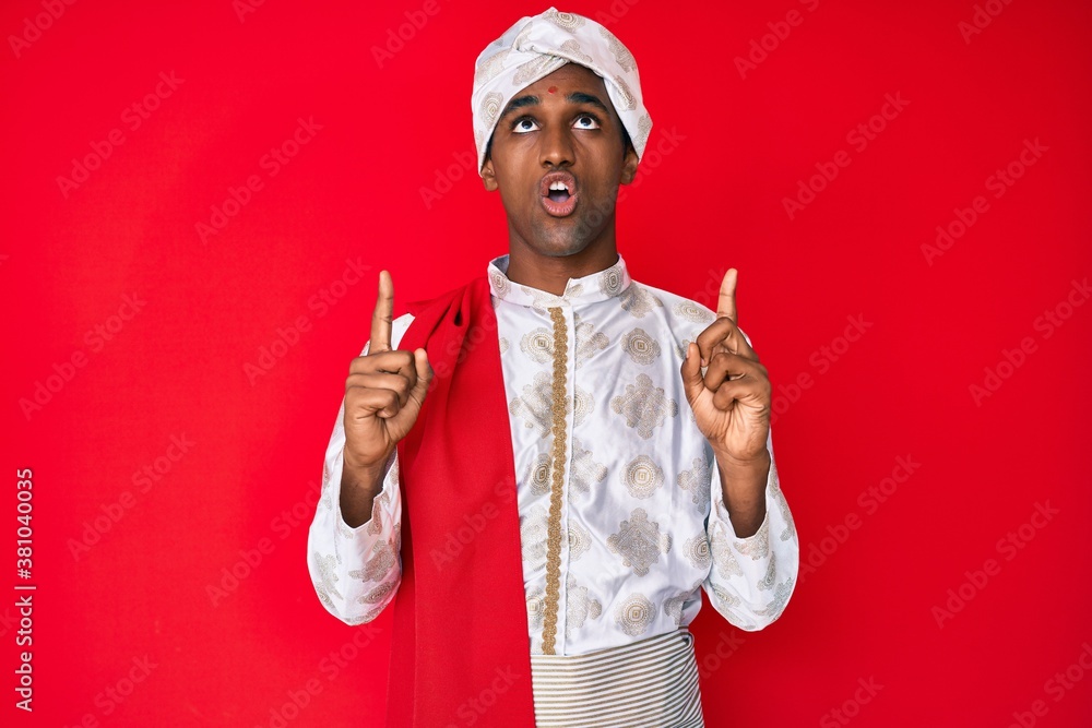 Handsome indian man wearing tradition sherwani saree clothes amazed and ...