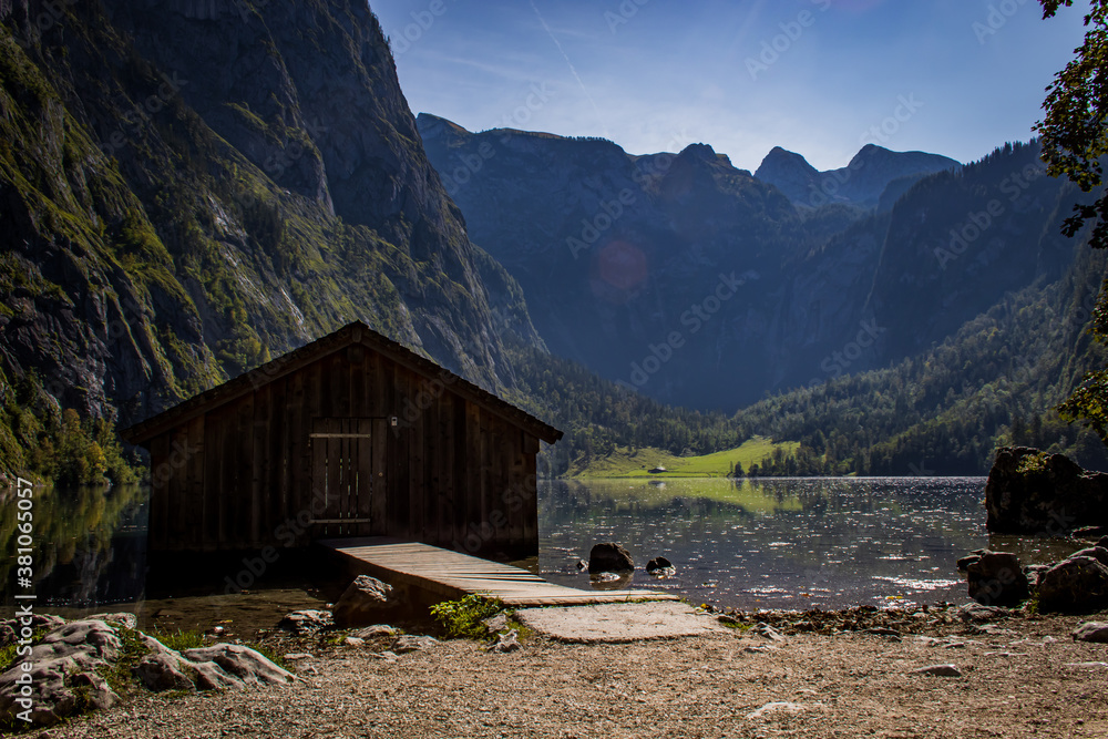 Bootshaus an klarem blauen See in den Alpen Stock Photo | Adobe Stock