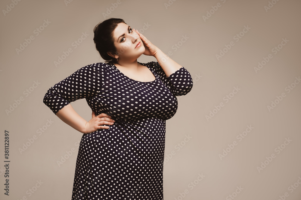 Plus size fashion model in polka dot dress, fat woman on studio ...