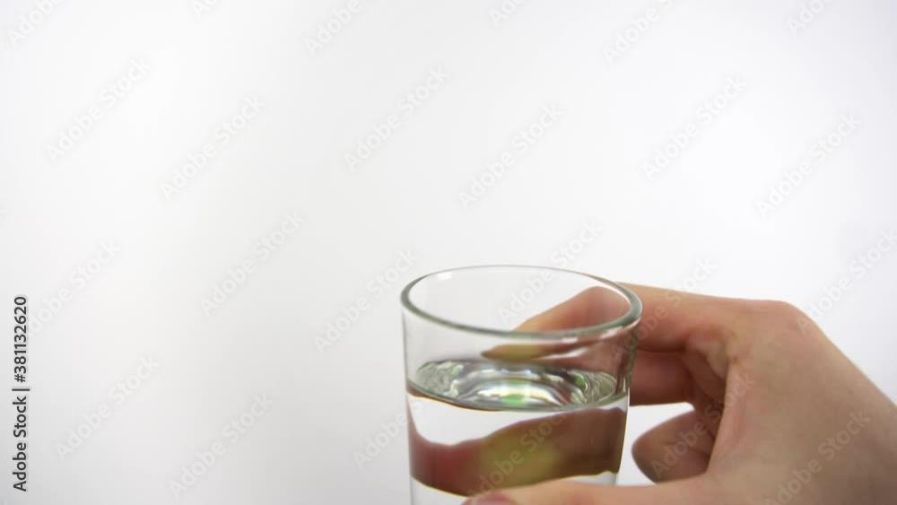 Vidéo Stock Man's hand is holding clear glass with water and drinks ...