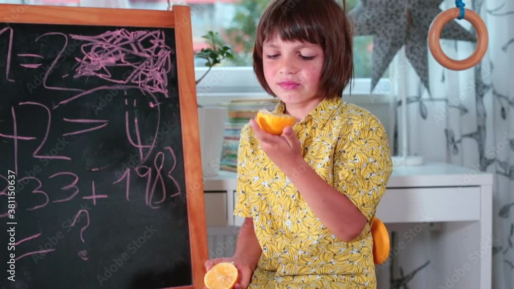 Boy exhibiting a funny expression make grimace after biting a fresh ...