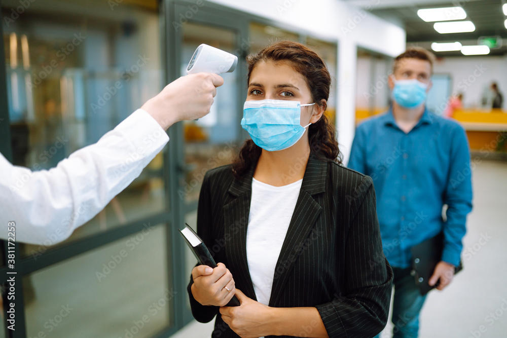 Disease control experts use an Infrared thermometer equipment to check ...
