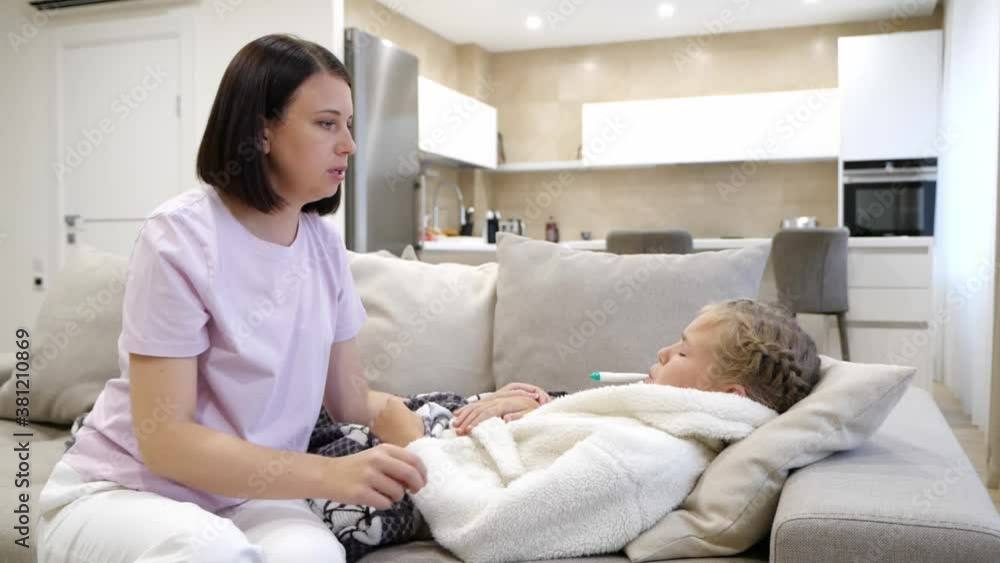 Stockvideo mother caring for sick child lying in bed with flu measuring temperature using ...