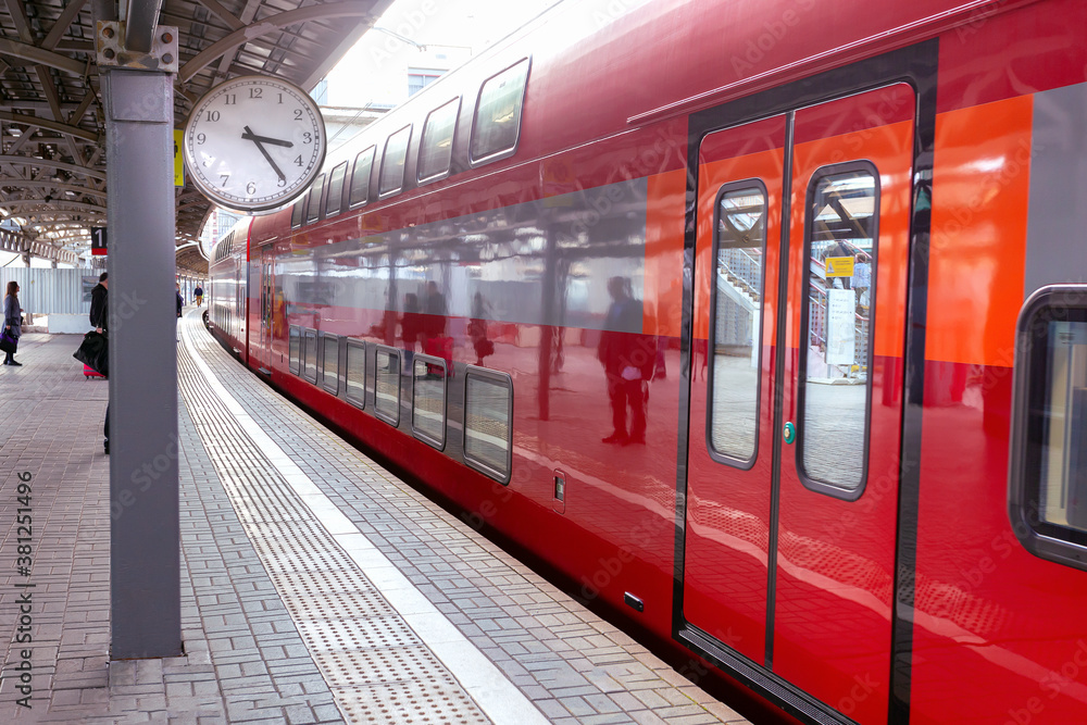 Modern train in the station with clock. Concept exactly on schedule ...