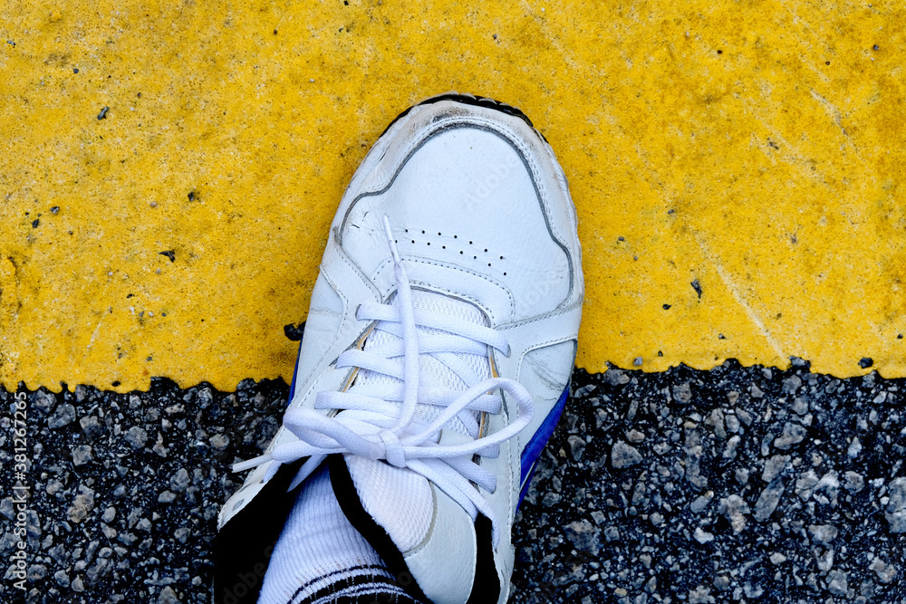 Fotografia do Stock: One leg or foot standing halfway on a road yellow ...