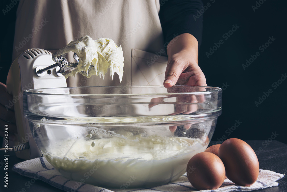 Lady is making cream cake using electric portable mixer machine Stock ...