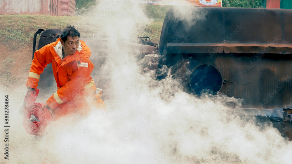 Firefighter fighting with flame using fire hose chemical water foam ...