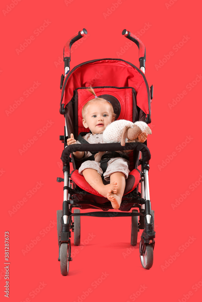 Cute little baby in stroller on color background Stock Photo | Adobe Stock