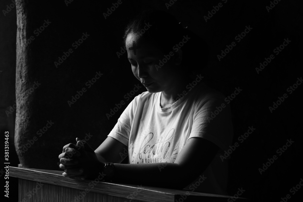 Portrait of young woman kneeling and praying in silent prayer pose, on ...