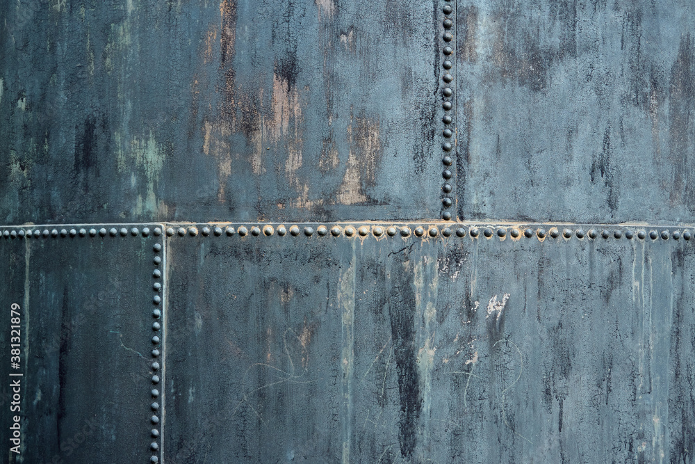 Part of an old storage container made of riveted iron plates, used and ...