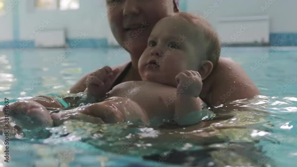 Family swimming in the pool with his cute little child. Happy family ...