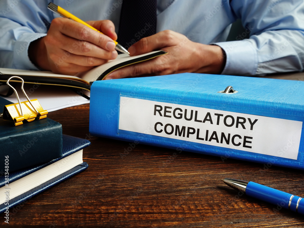 Regulatory compliance papers in the folder and manager. Stock Photo ...