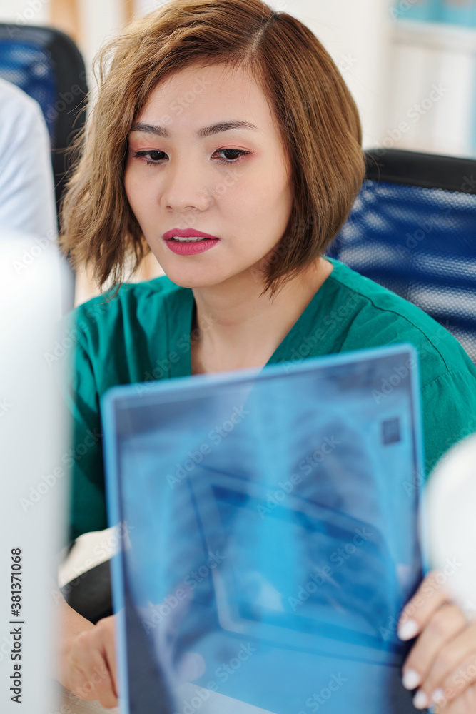 Young Asian pulmonologist examining lungs x-ray of patient Stock Photo ...