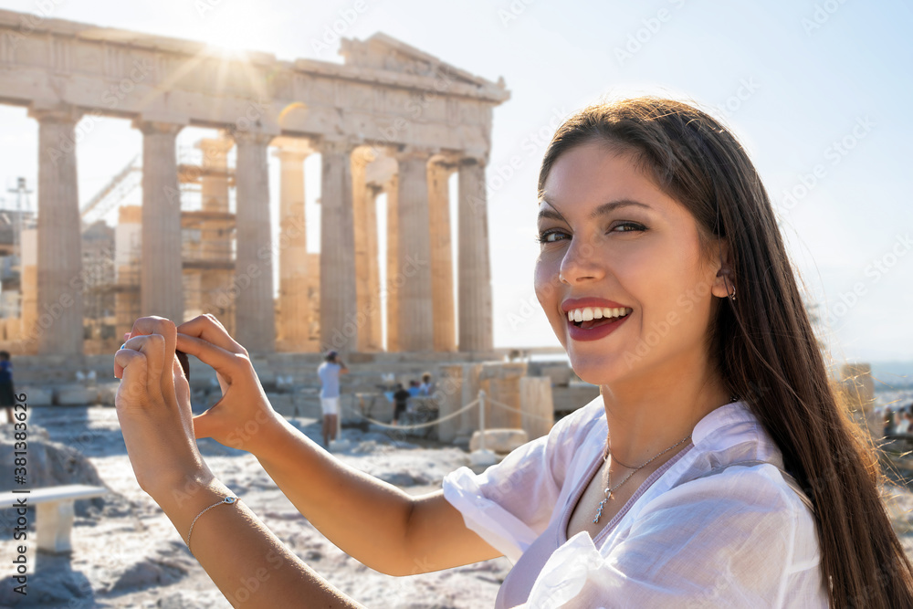 Portrait of a pretty tourist woman takes pictures of the Parthenon ...