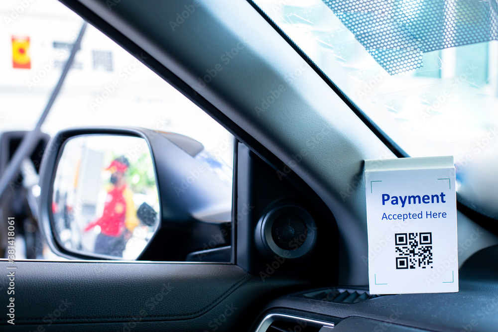 QR code payment tag with blurry image on wing mirror of staff in gas ...