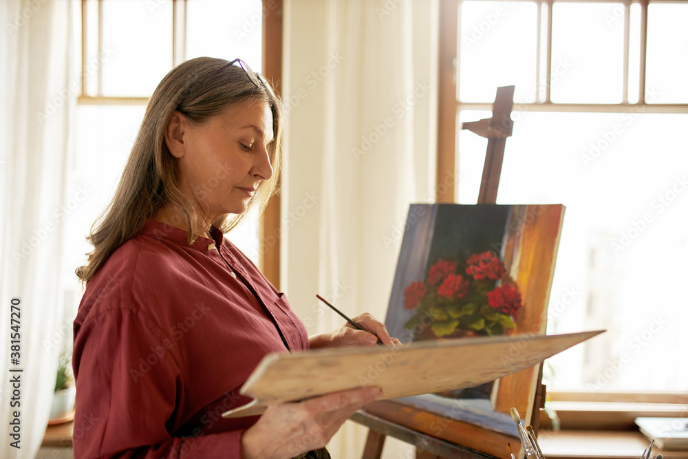 Portrait of talented beautiful middle aged female attending art ...
