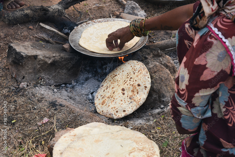 Indian woman making Indian flat bread tandoori roti with hand in ...