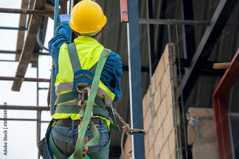 Construction worker wearing safety harness and safety line working at ...