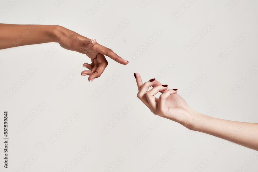 Close up of two hands of diverse women reaching for each other isolated ...
