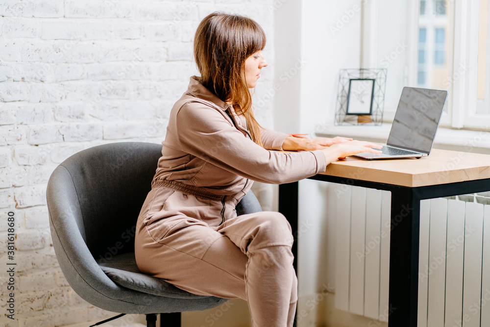 The correct position posture when working at the computer. A woman sits ...