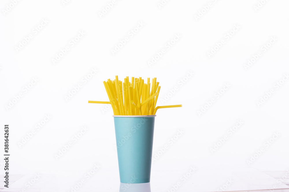 Bunch of yellow plastic straws in blue disposable biodegradable paper ...