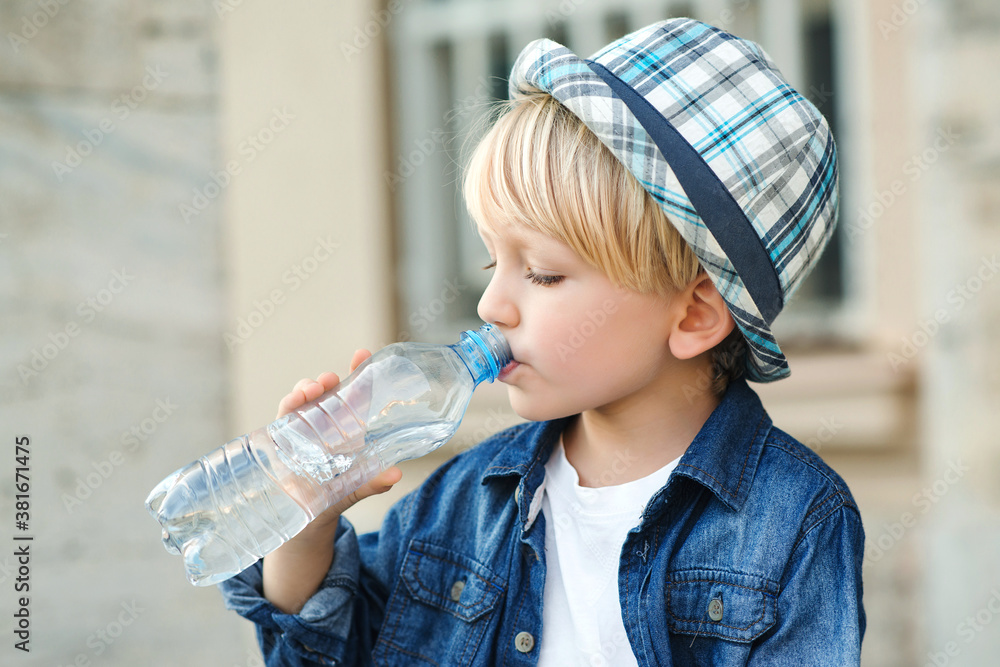 Cute little boy drinking water from the plastic bottle. Child drinks ...