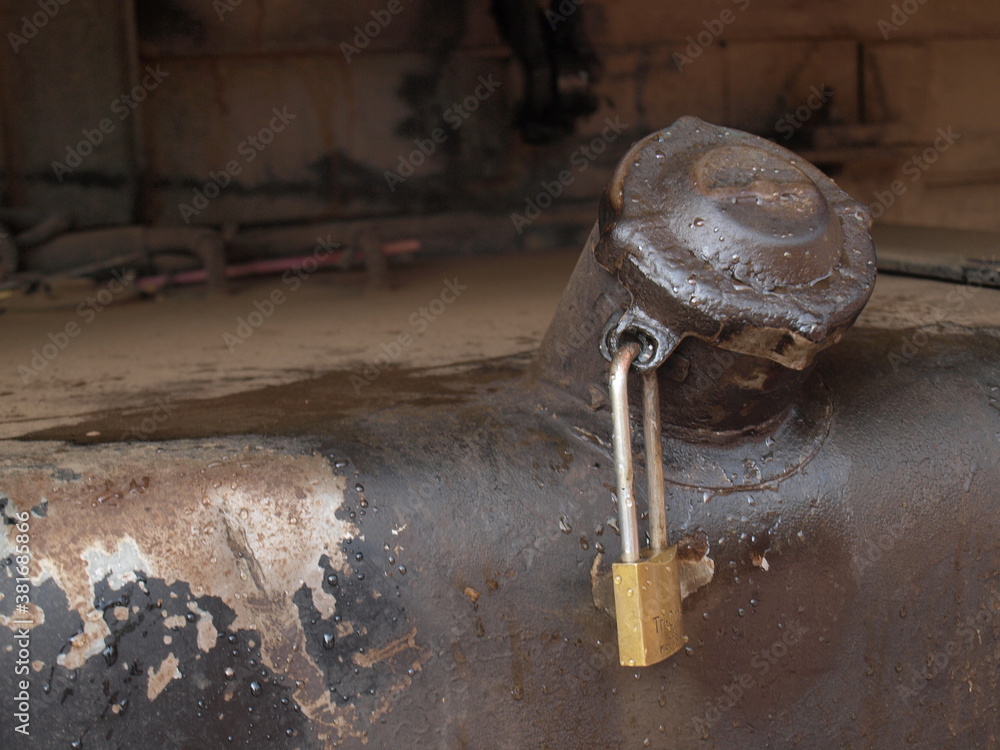 Padlock on the old oil tank is dirty. To prevent the car oil from being ...