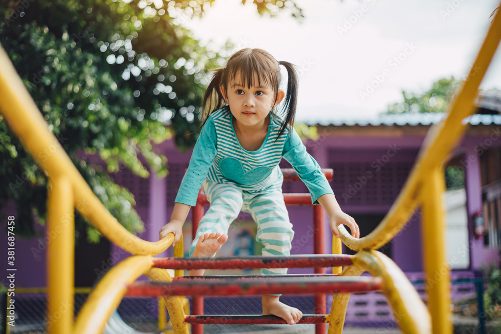 Kids having fun by climbing up ladders at the playground in the park ...