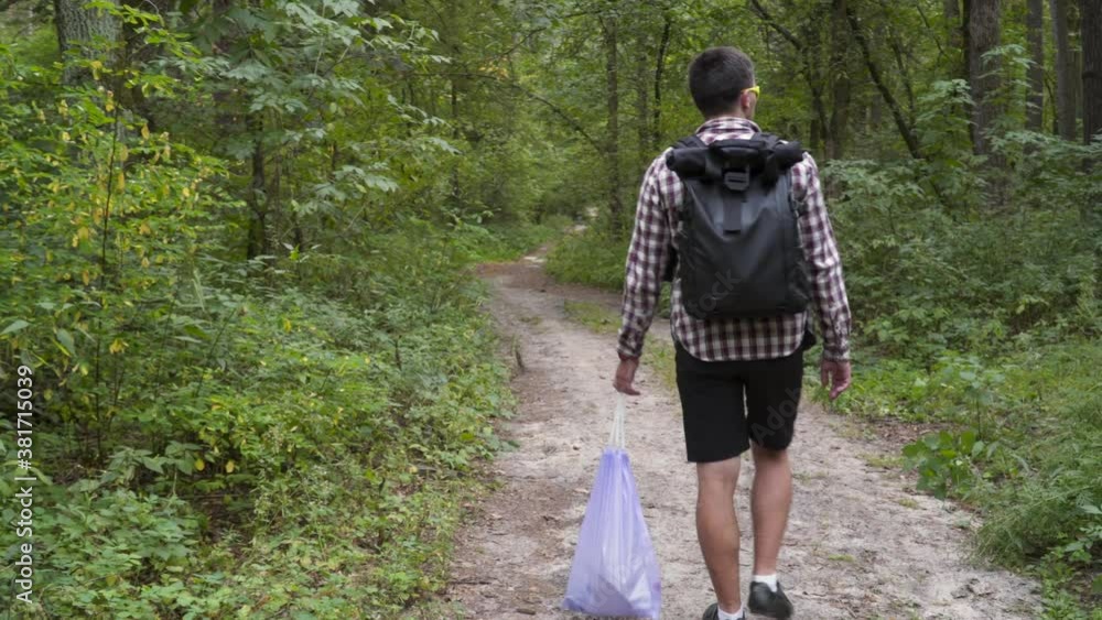 Young man throwing litter garbage from plastic bag on ground ...