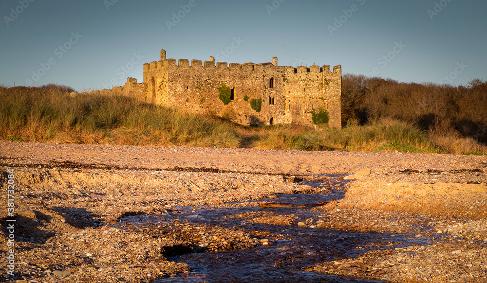 Manorbier castle in West Wales as seen from the pebble beach, a Norman ...