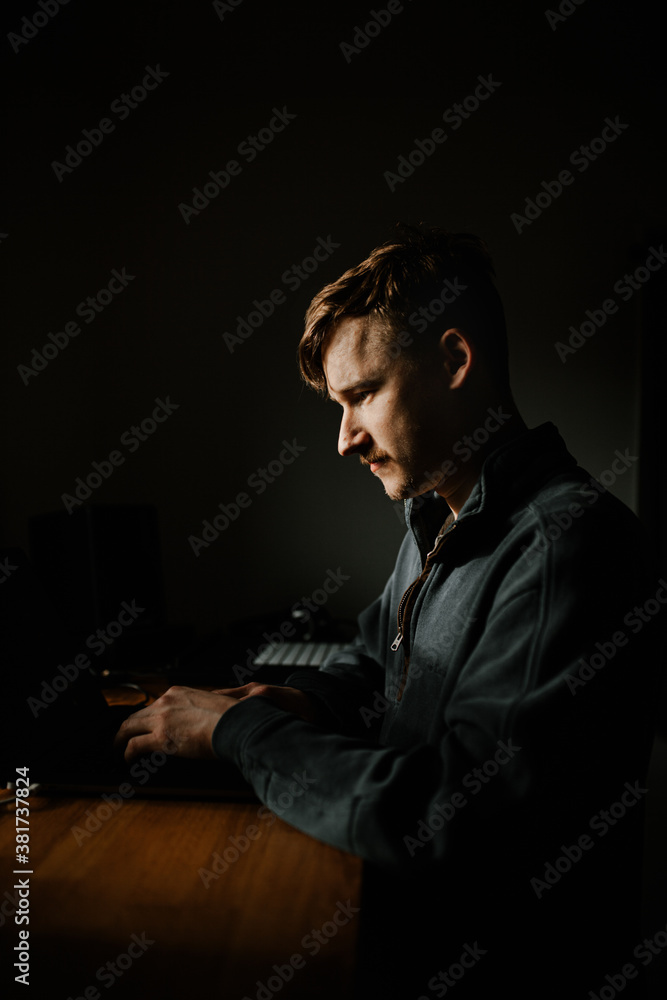 Young Man Using Laptop In Darkroom Stock Photo | Adobe Stock