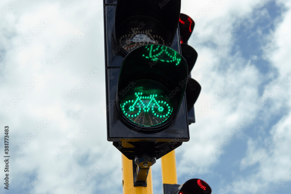 Closeup to a green traffic light near to a vehicular traffic light in a ...