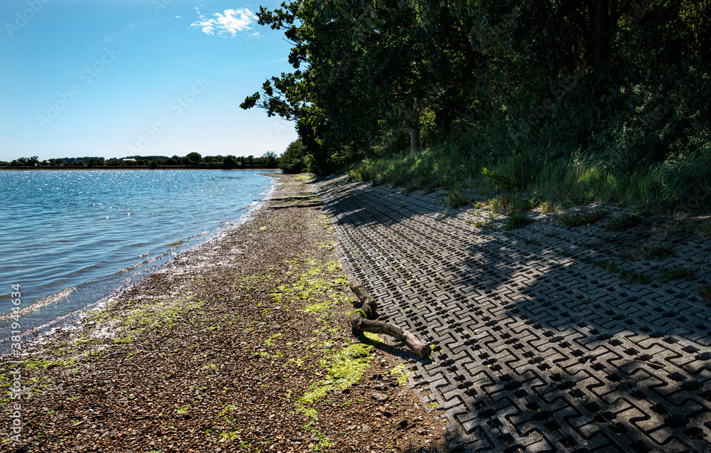 Sea retaining wall built along pebble beach to prevent erosion. Stock ...
