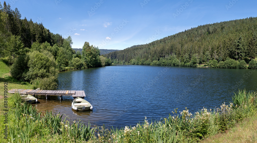 Idyllischer See mit Boot am Holzsteg, aufgenommen an der ...
