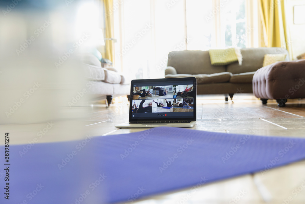 Exercise class streaming on laptop screen behind yoga mat Stock Photo ...
