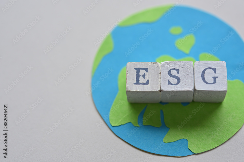 There is the earth and word cube formed "ESG" which are placed on a ...
