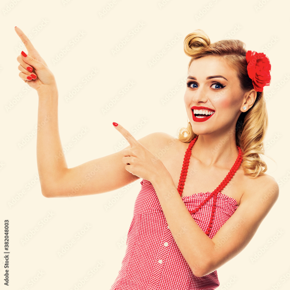 Amazed happy woman pointing at something. Excited girl in pin up ...