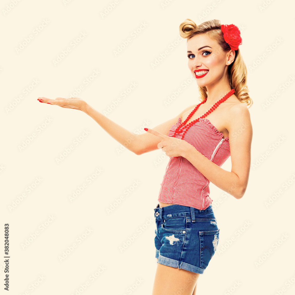 Happy smiling blond woman holding or giving. Excited girl in pin up ...