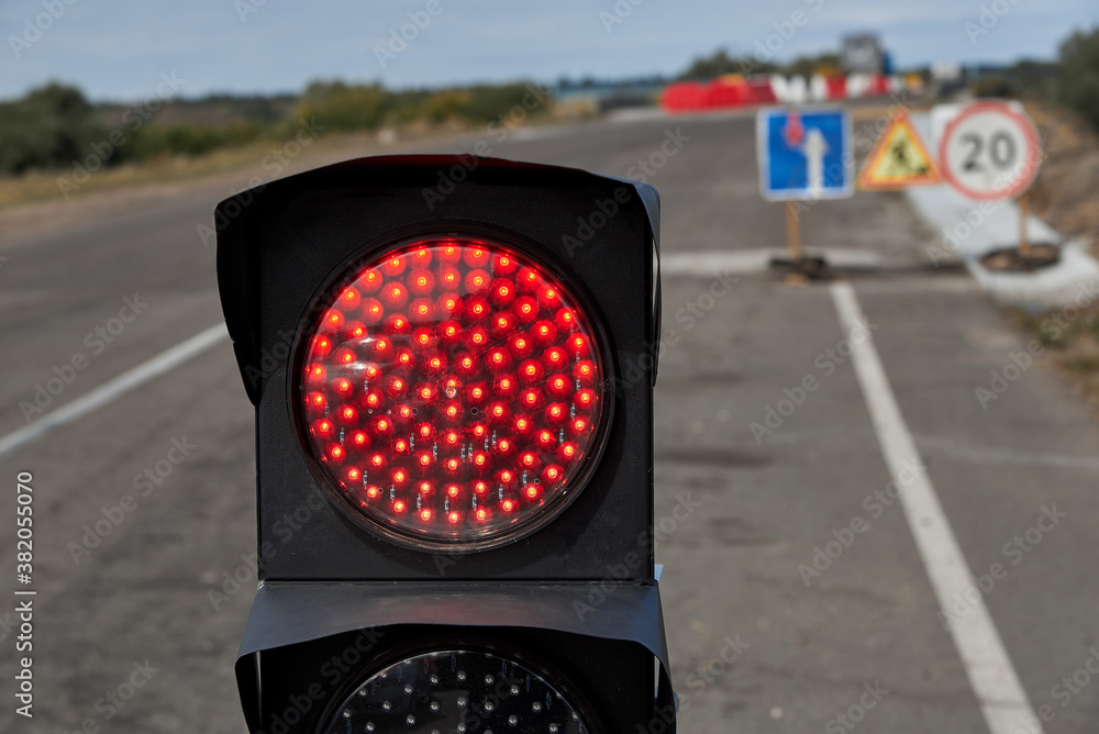 The traffic light is red, repairs on the asphalt road, road signs ...