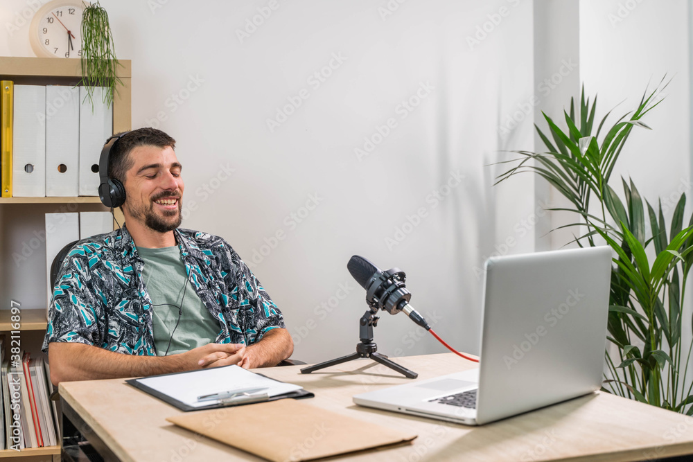 Man working as radio host at radio station sitting in front of ...