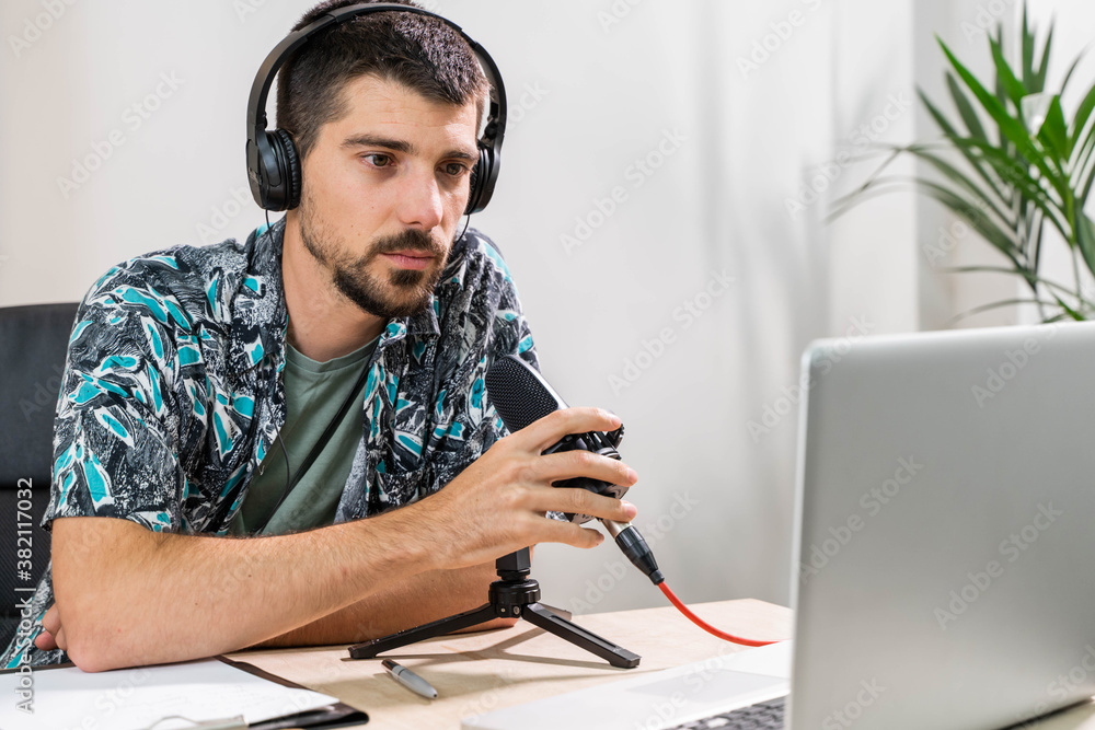 Man working as radio host at radio station sitting in front of ...