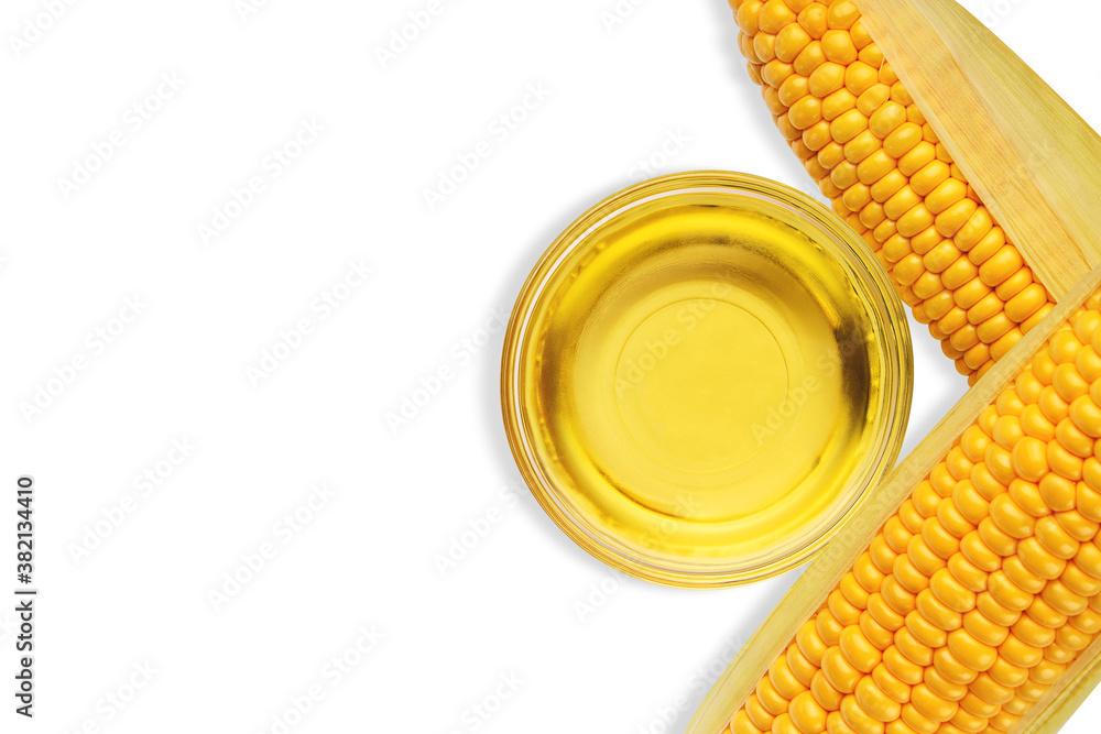 Corn oil in a bowl and corn cobs on a white background with copy space ...